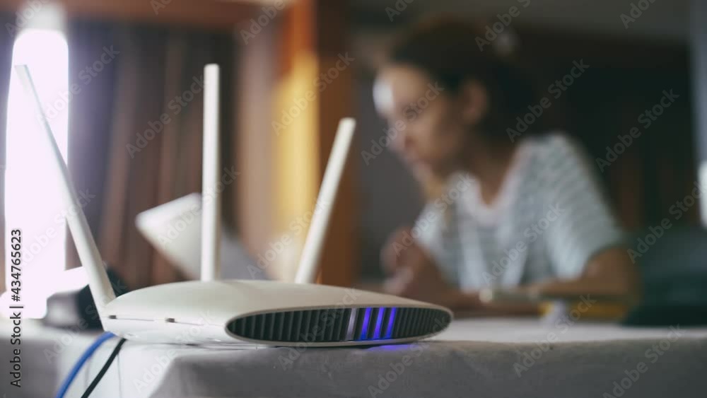 A woman is working at home using a modem router, connecting the ...