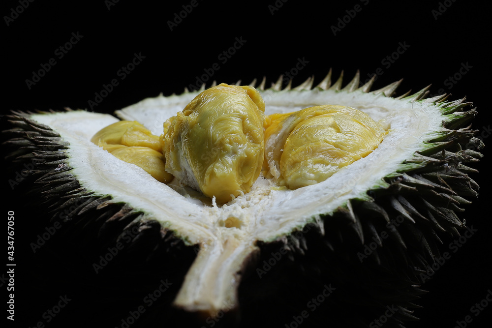 The durian fruit cut open to reveal fleshy inside. Durian is known as the king of fruit in Asia ...