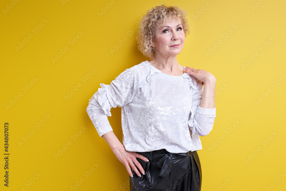 Elegant attractive lady of 60 years ols in stylish outfit posing at ...