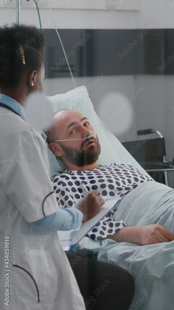 Afro american doctor checking sick man monitoring sickness symptom ...