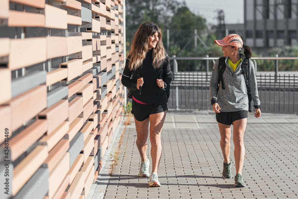 Smiling multi-ethnic women preparing to go for a run together. Two ...