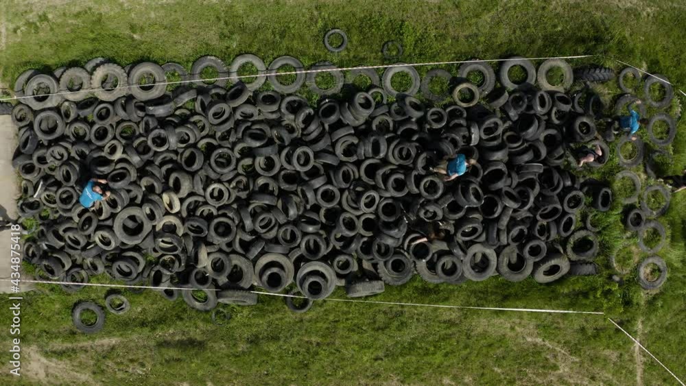 Man running through tires as part of an assault course. Man running ...