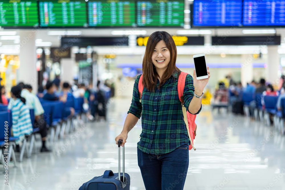 Asian traveler with luggage showing the smart mobile phone for check-in ...