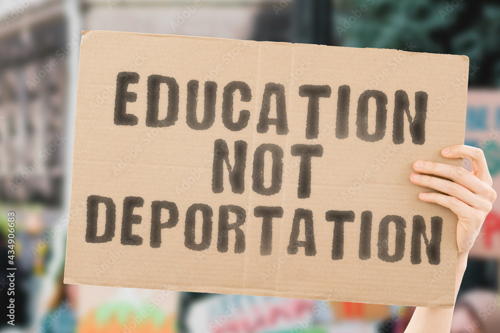 The phrase " Education not deportation " on a banner in men's hand ...