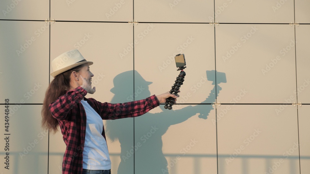 Young girl blogger is conducting an online video conference from city ...