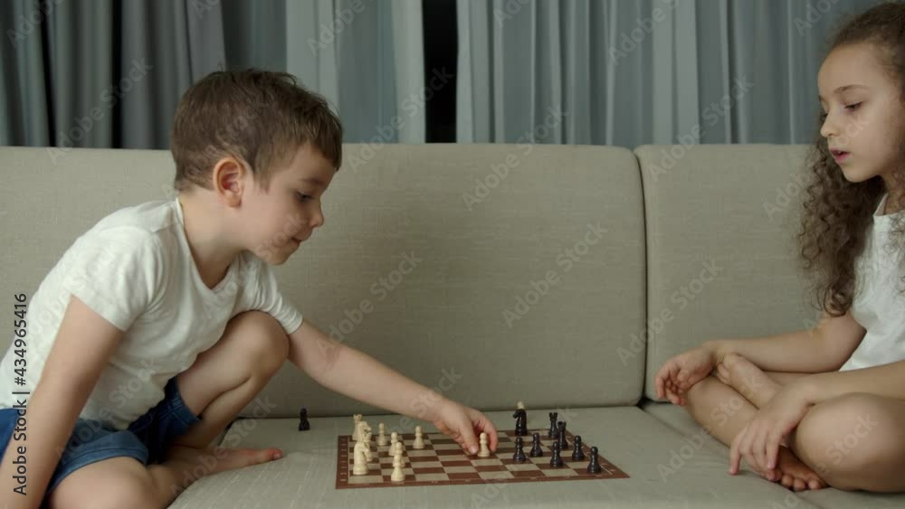 Children play chess while sitting on the devan at home, the development ...