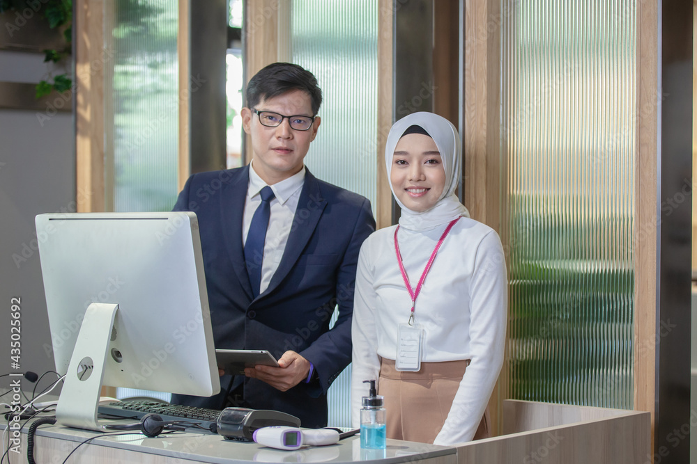 young Asian reception team hotel front desk welcoming . Asian reception ...