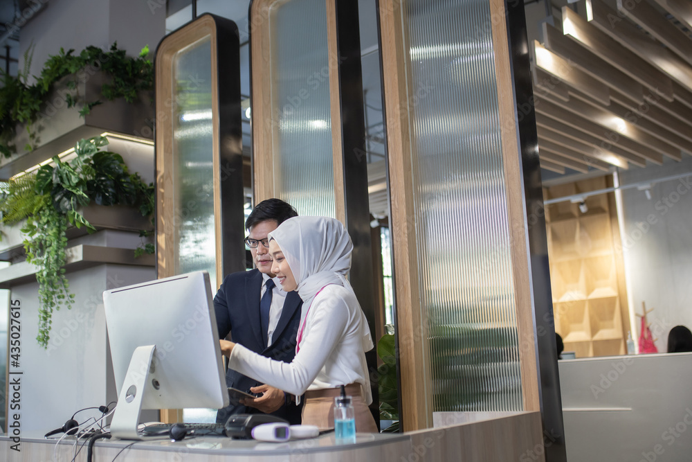 young Asian reception team hotel front desk welcoming . Asian reception ...