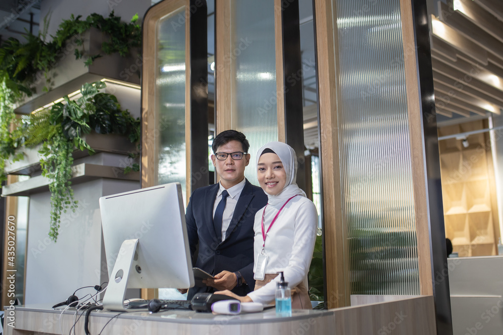 Foto de young Asian reception team hotel front desk welcoming . Asian ...