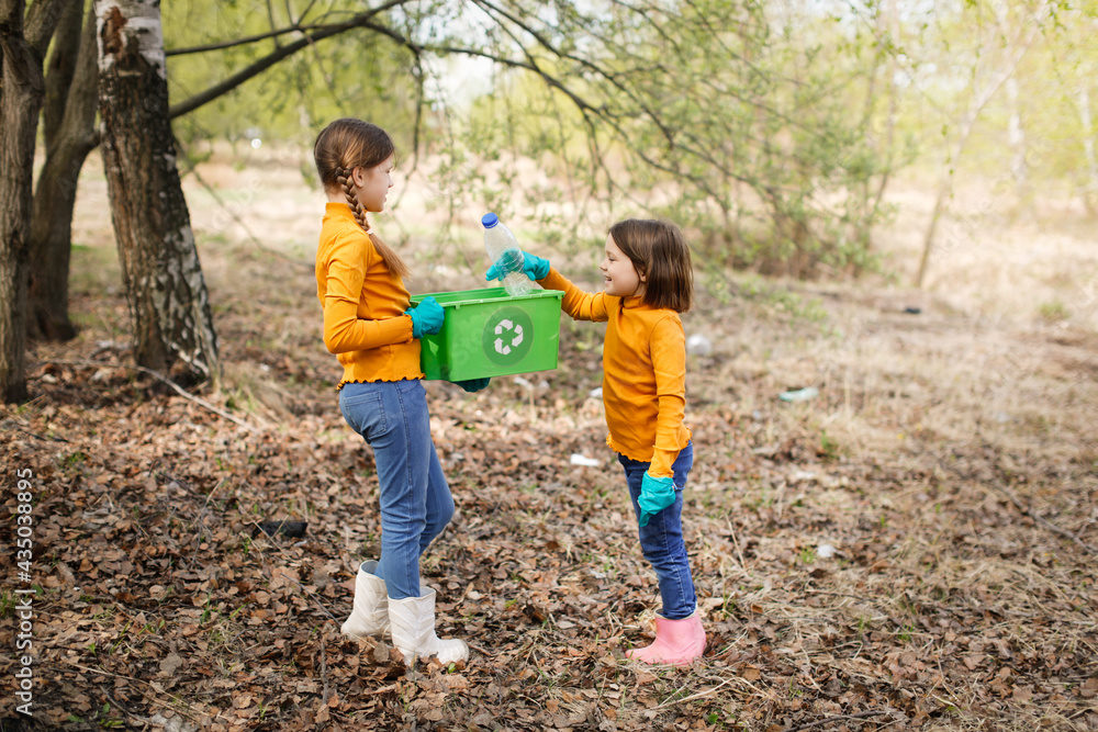 Foto de girls children clean up the garbage in the park, in the forest ...