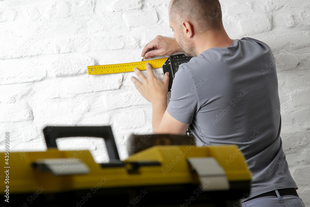 Man measuring white brick wall and drawing markers. Stock-Foto | Adobe ...