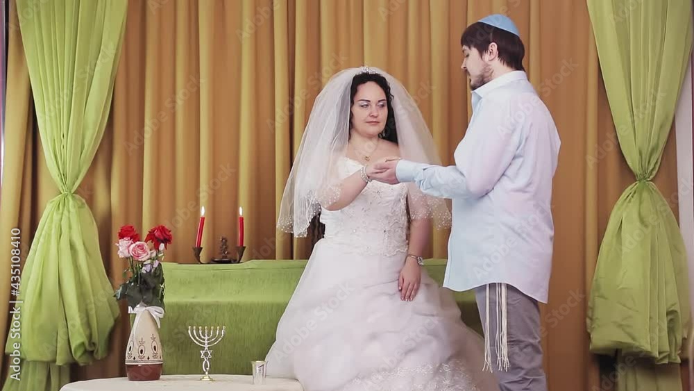 During the chuppah ceremony, a Jewish bride and groom in a synagogue ...