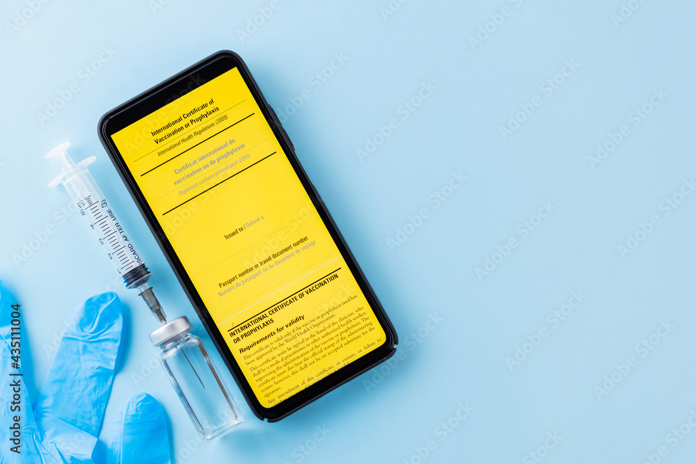Yellow international certificate of vaccination, vaccine vial and ...