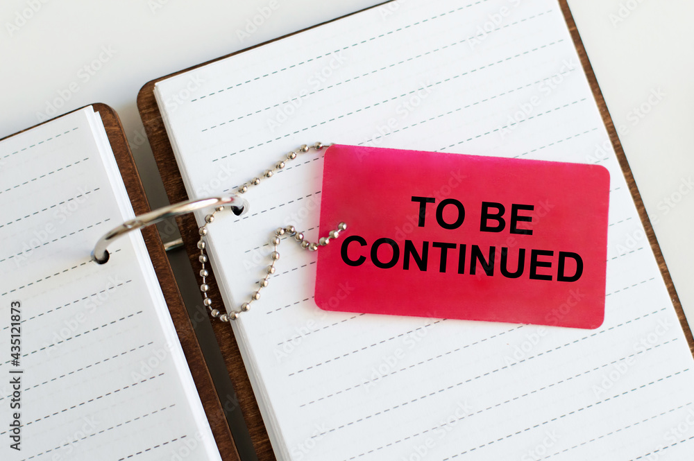 text TO BE CONTINUED red card on notepad, business concept, Finance ...