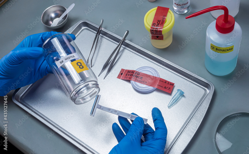 Forensic police take razor blade from victim in crime lab for analysis ...
