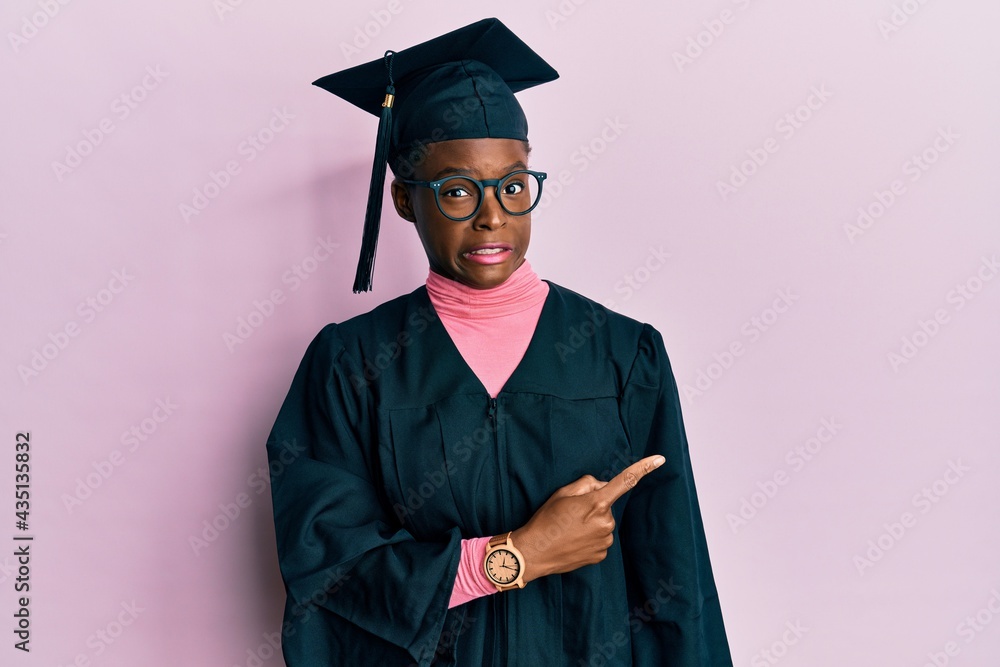 Young african american girl wearing graduation cap and ceremony robe ...