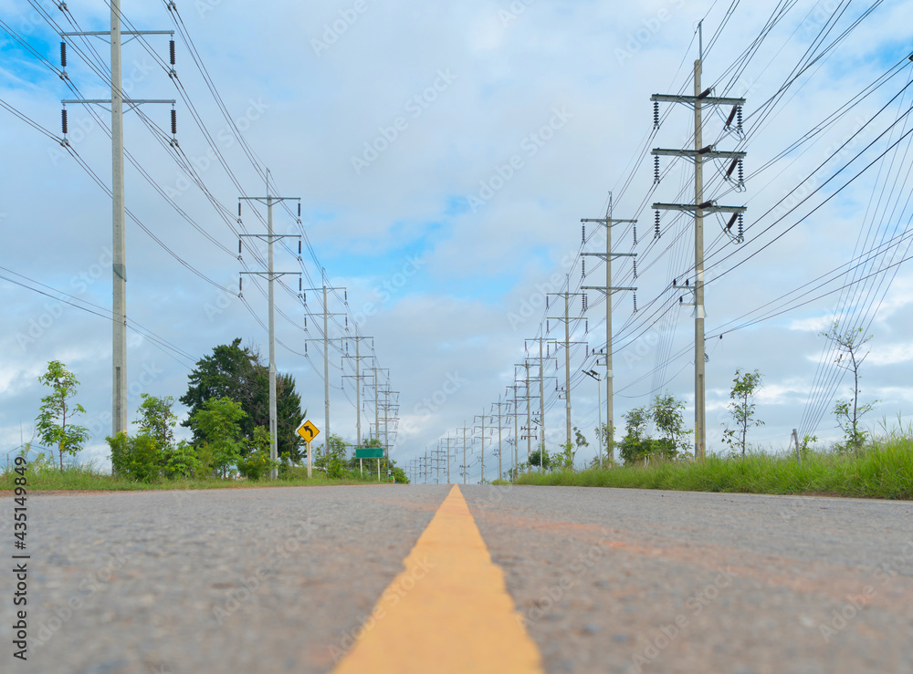 High voltage poles with street road. Power lines on utility tower and ...