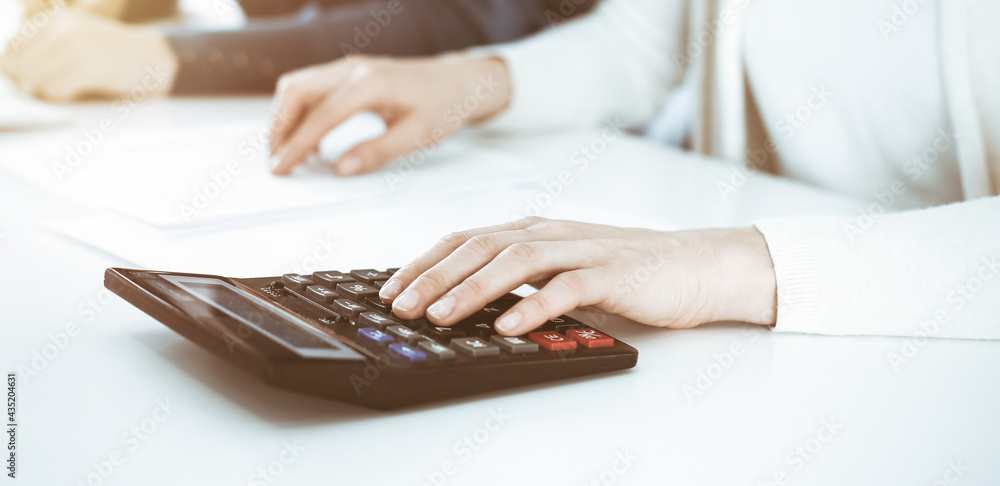 Accountant checking financial statement or counting by calculator ...