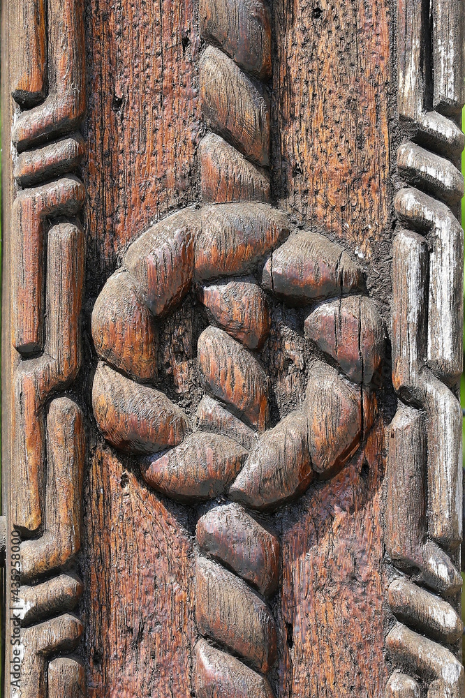 An old sculpture on the pillar of a gate in the city of Reghin ...