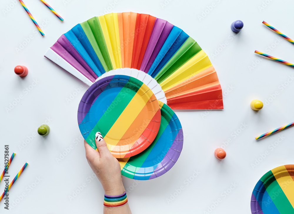 LGBTQ community pride month rainbow concept flat lay. Hand with ribbon ...