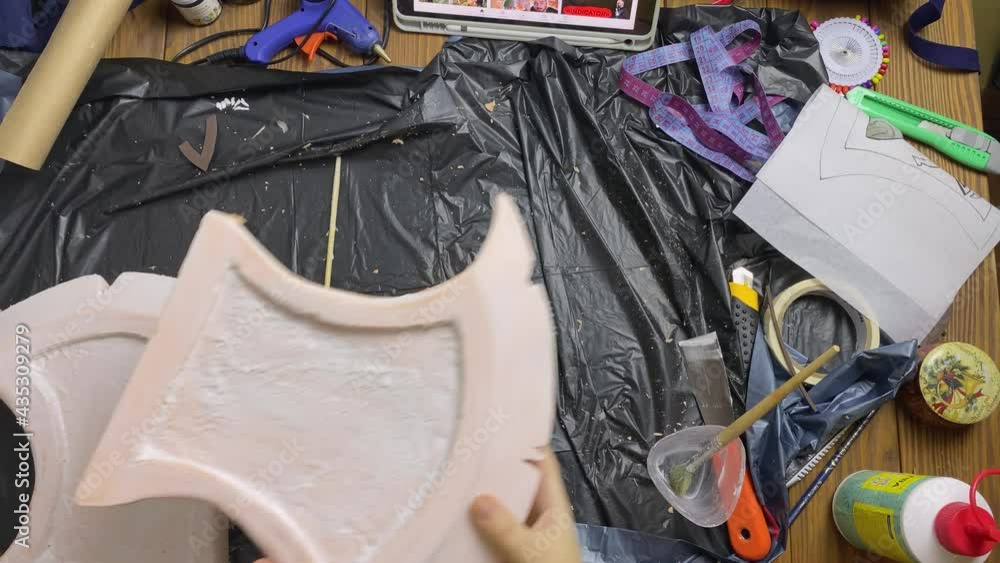 Piece from styrofoam axe in woman's hands. Celtic hatchet made of ...