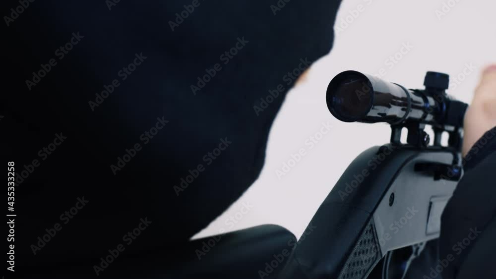 The police sniper makes adjustments to the telescopic sight of the ...