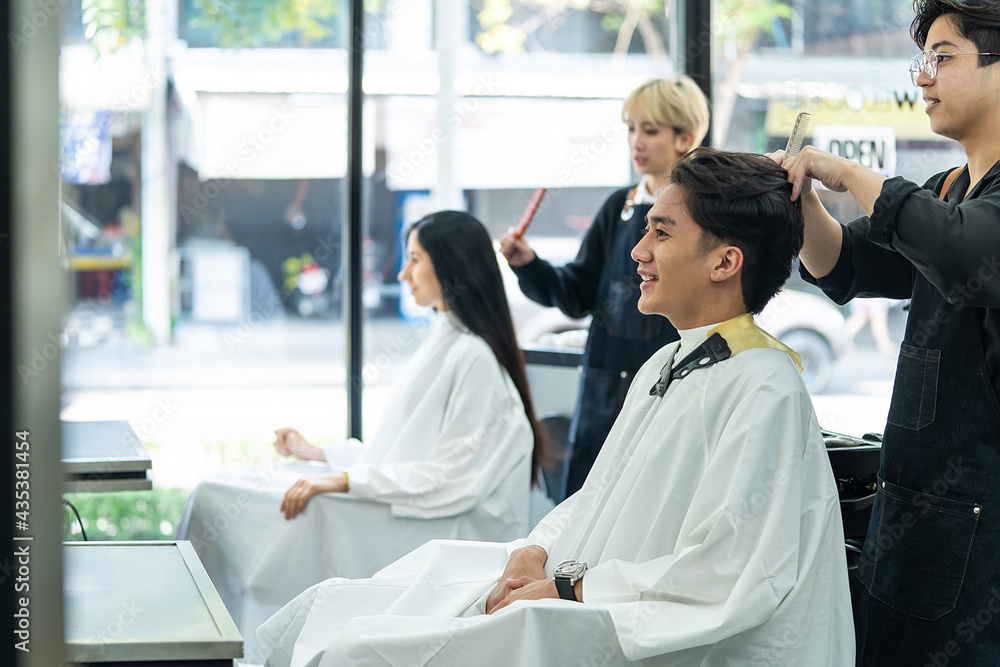 Professional hairdresser team providing haircut service to customer ...