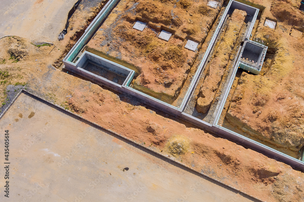 Building site of trenches dug in ground and filled with cement as ...