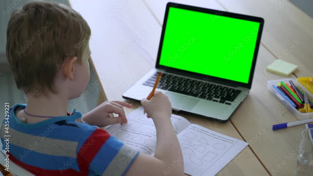 Boy uses green screen chroma key laptop for learning on online class ...
