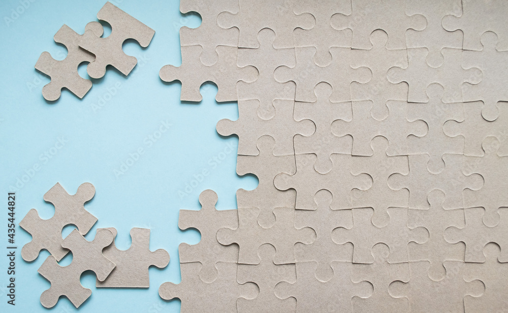 Unfinished cardboard puzzle without pattern. A blue background on the ...