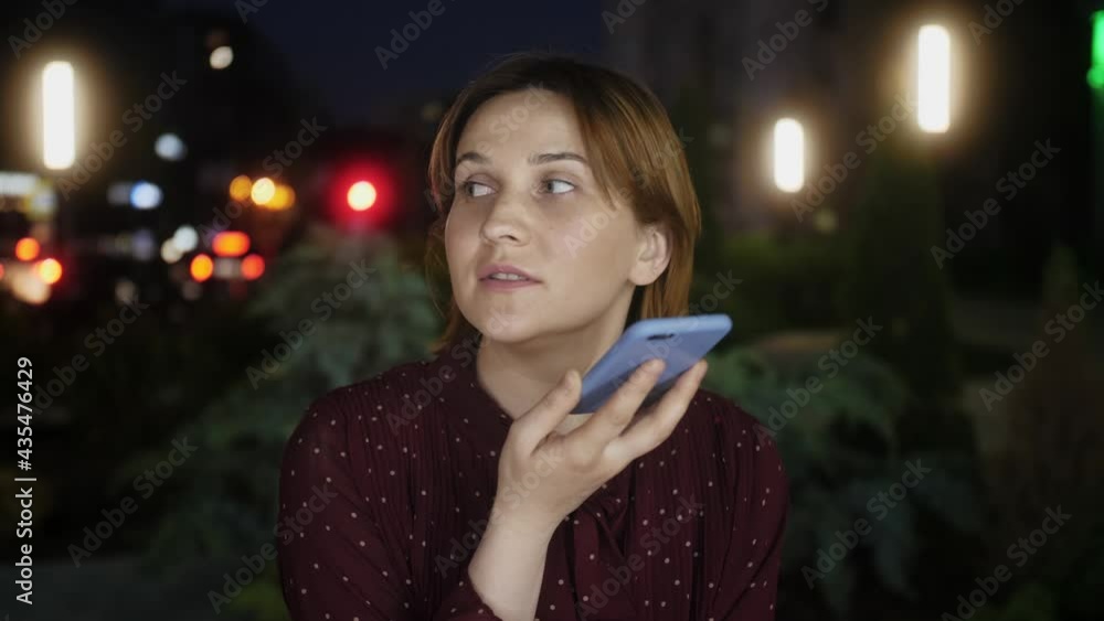 Woman makes short phone call by speakerphone, using telephone function ...