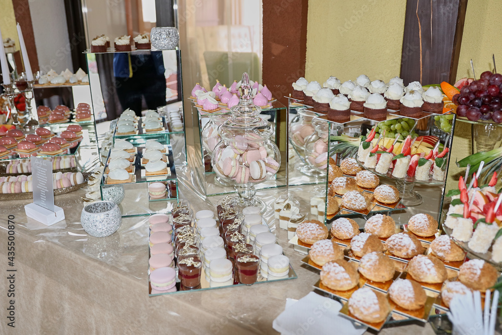 Festive sweet table. Candy bar with cakes, pastries, mousses and fruit ...