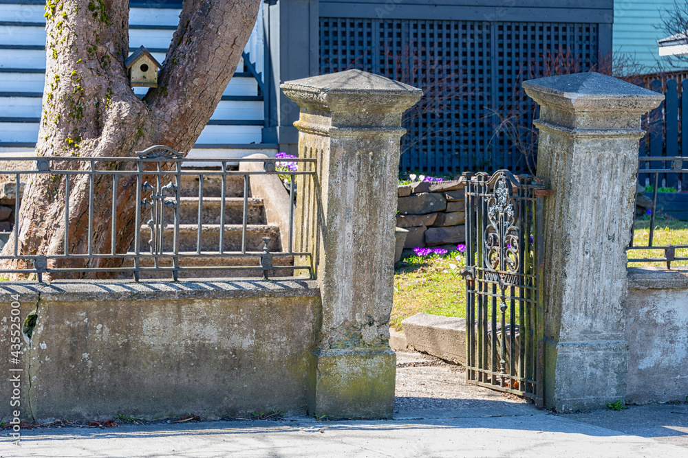Large square concrete gate posts with a small decorative wrought iron ...