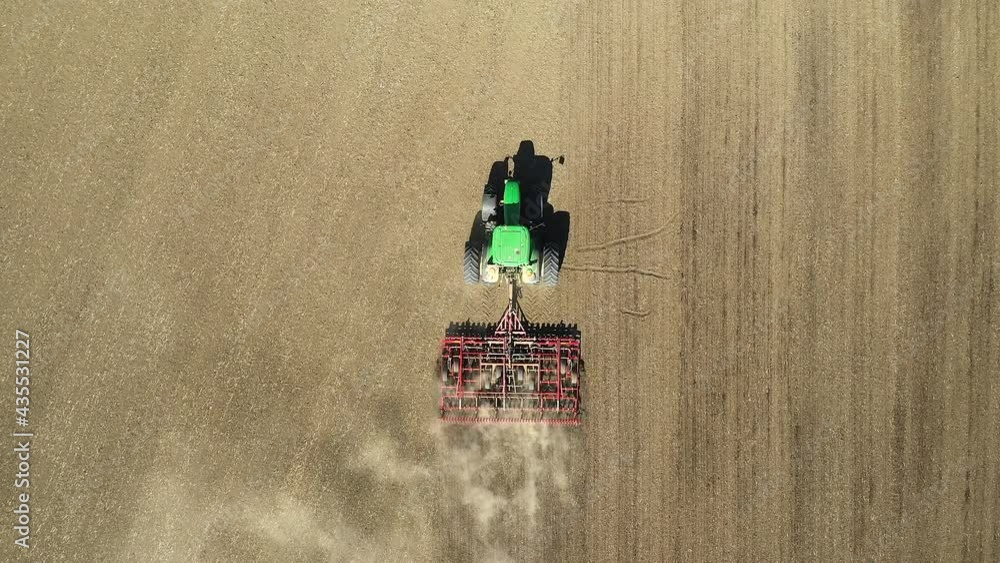 Low altitude aerial top down view of green double wheeled tractor ...