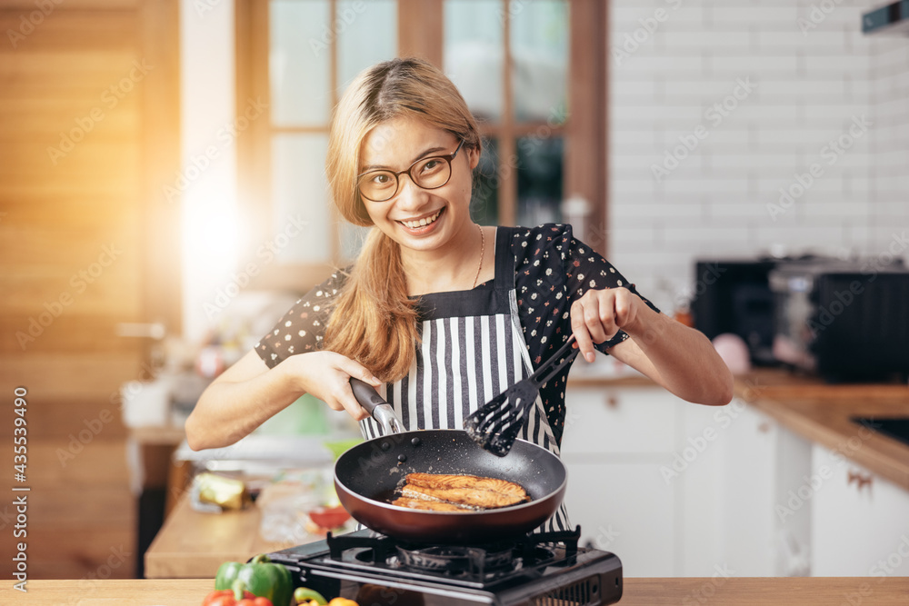 happy young woman smiling in a modern kitchen. beautiful Asian woman ...