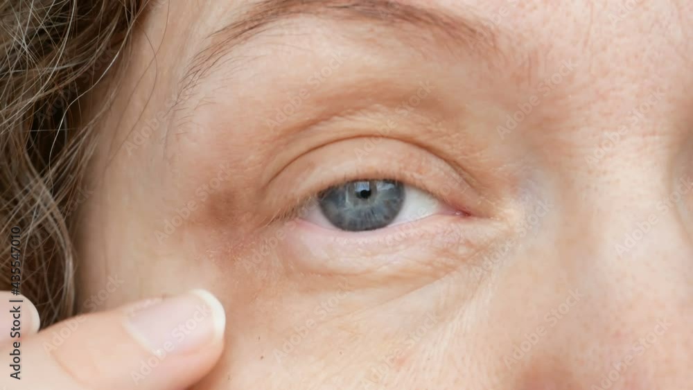 middle-aged woman does corrective eye makeup to correct the drooping ...