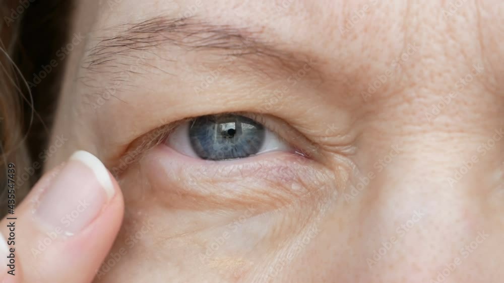 middle-aged woman does corrective eye makeup to correct the drooping ...