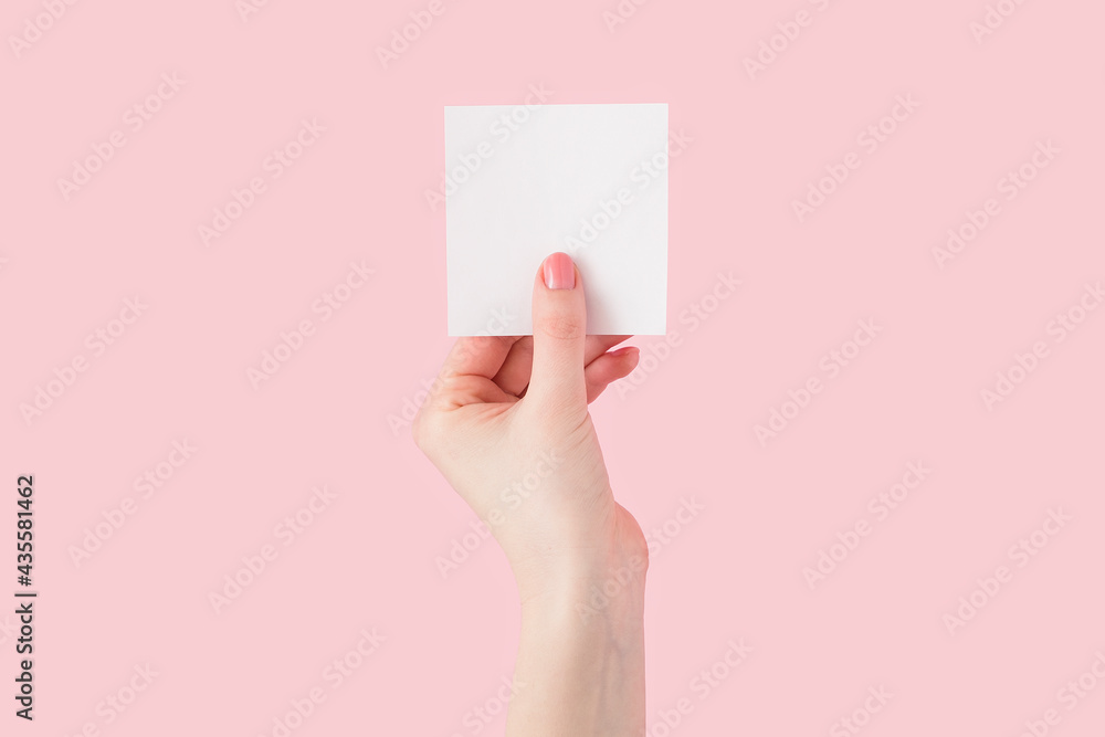 Sticker. Blank sheet of paper in female hands on a pink background ...