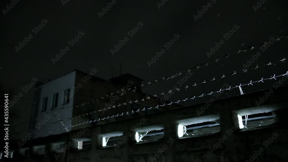 prison barbed wire over concrete fence against cloudy sky at cold dark ...