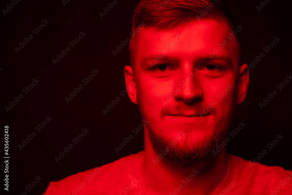 Young attractive male person posing in contrast red light. Portrait of ...