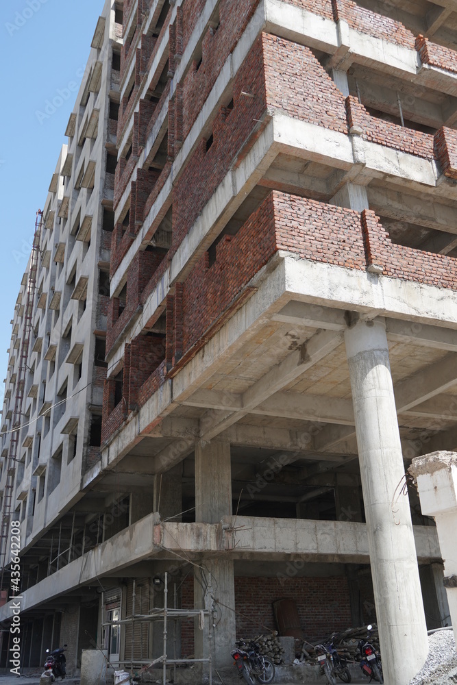 Building under construction against blue sky. General view of the ...