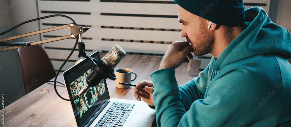 Handsome content creator streaming his live podcast using professional ...