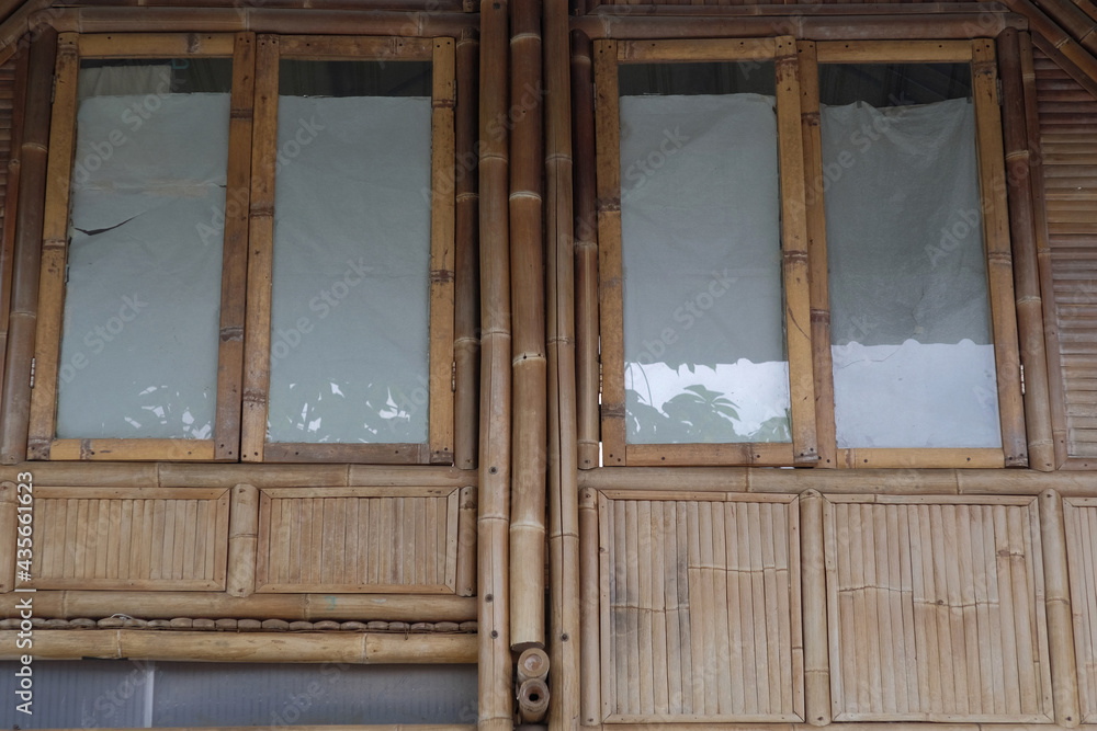 Glass windows with frames and walls made of bamboo in an ecological ...