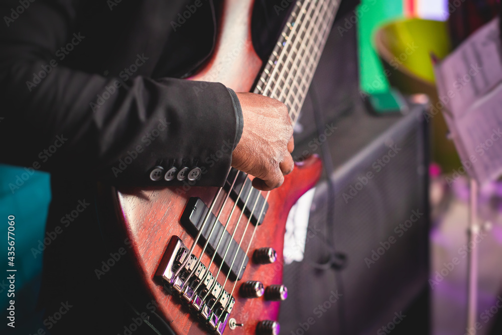Concert view of an african-american musician with electric bass guitar ...