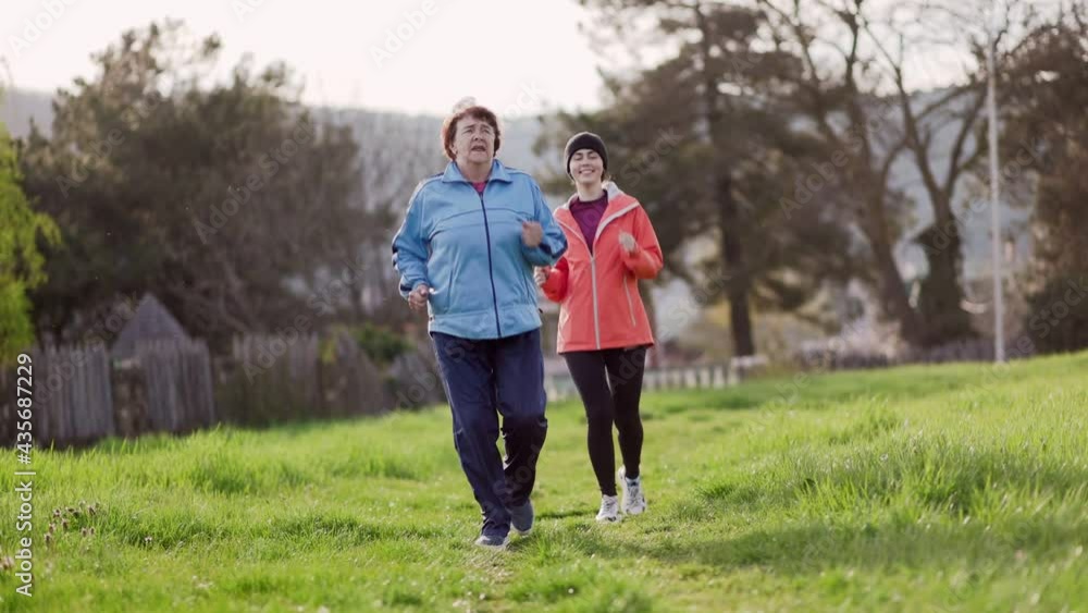 Grandmother and granddaughter running together. Slow motion ...