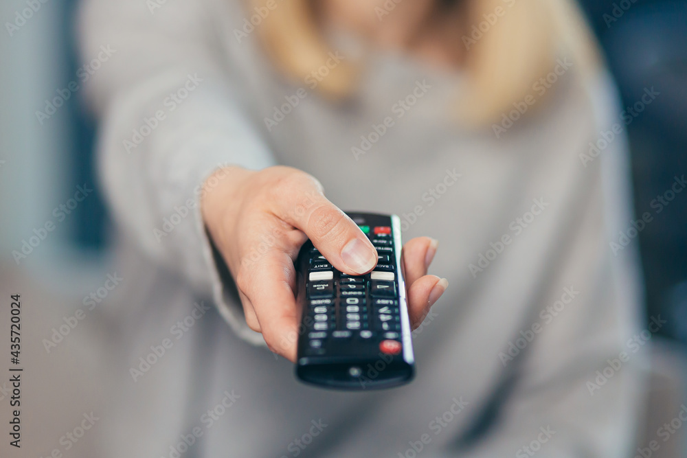 Woman holding a remote control from the TV switches channels Stock ...