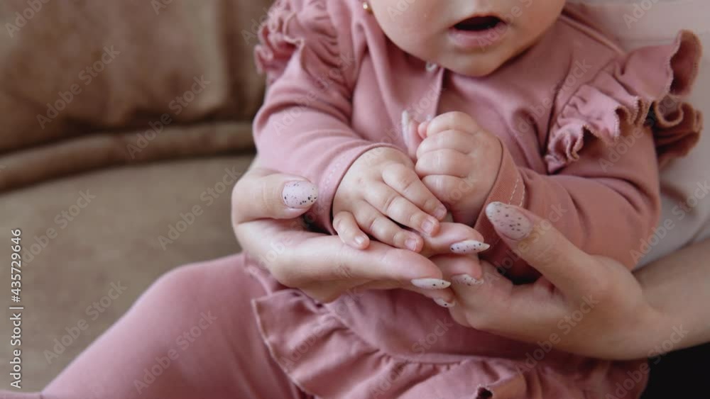 Baby's hands in mother's hands. Close-up view of hands. Baby girl with ...