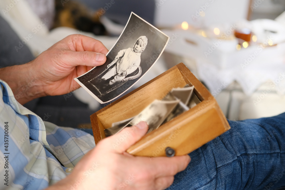 Stockfoto an elderly man looks through his old photographs of 1960-1965 ...