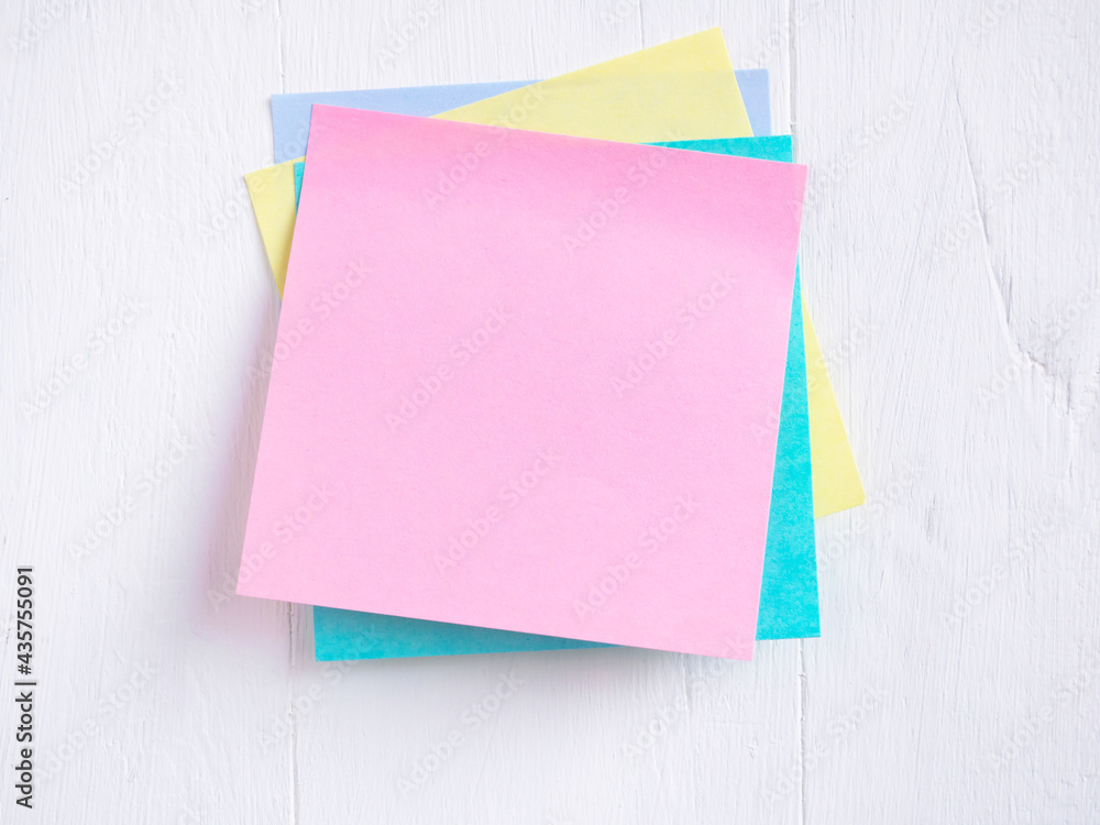 Sticky note ( Post-it) stack on a white wooden. Blank space for text ...