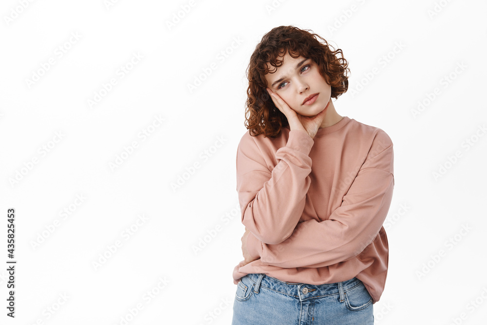 Sad and tired young woman, lean head on hand and look away with spaced ...